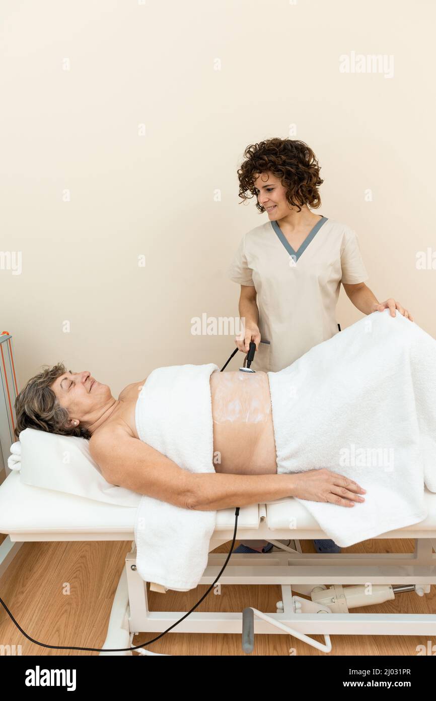 woman receiving treatment with radiofrequency machine for stimulation ...