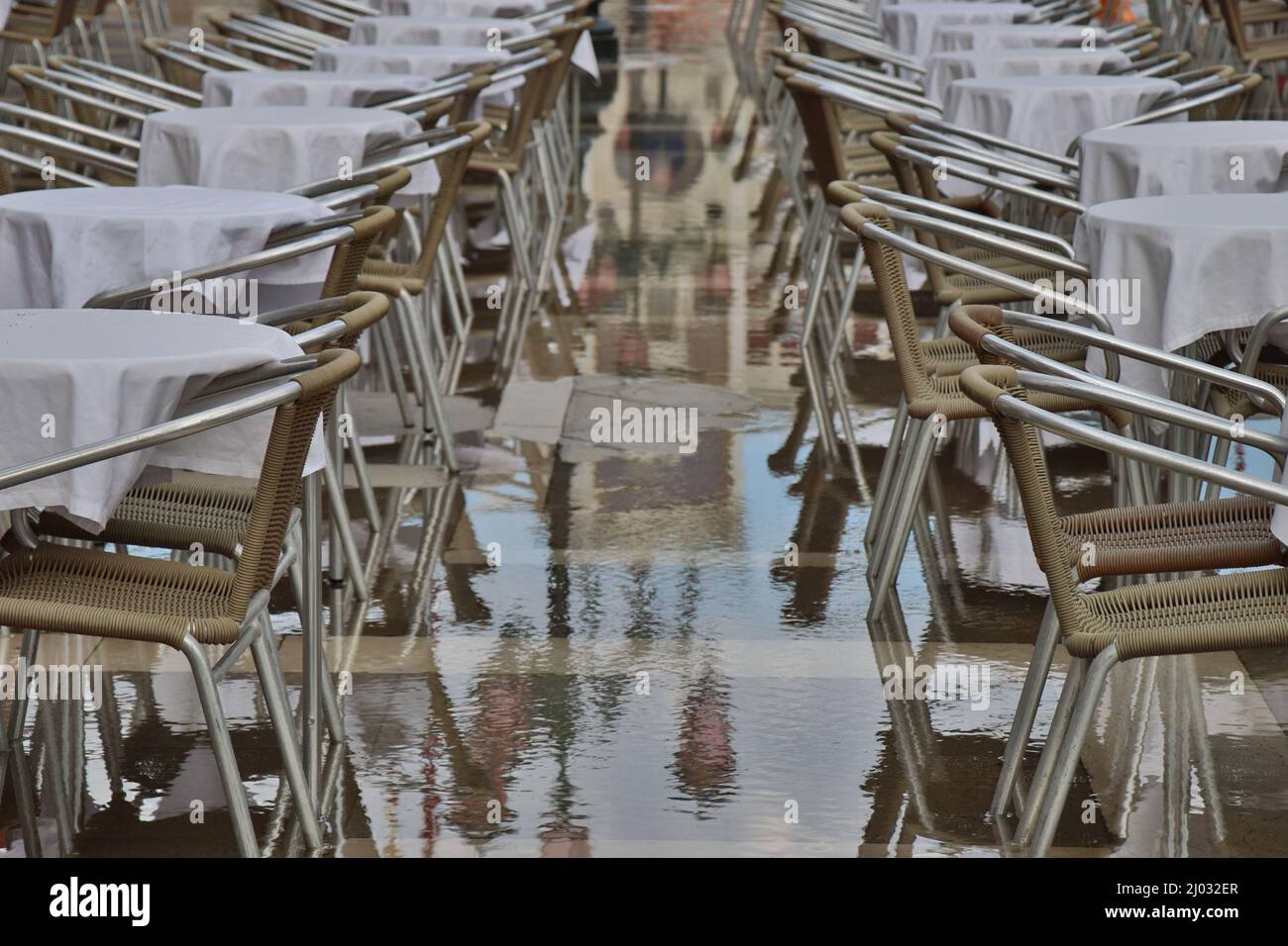 Beautiful shot of chairs in a row with water reflection in Venice ...