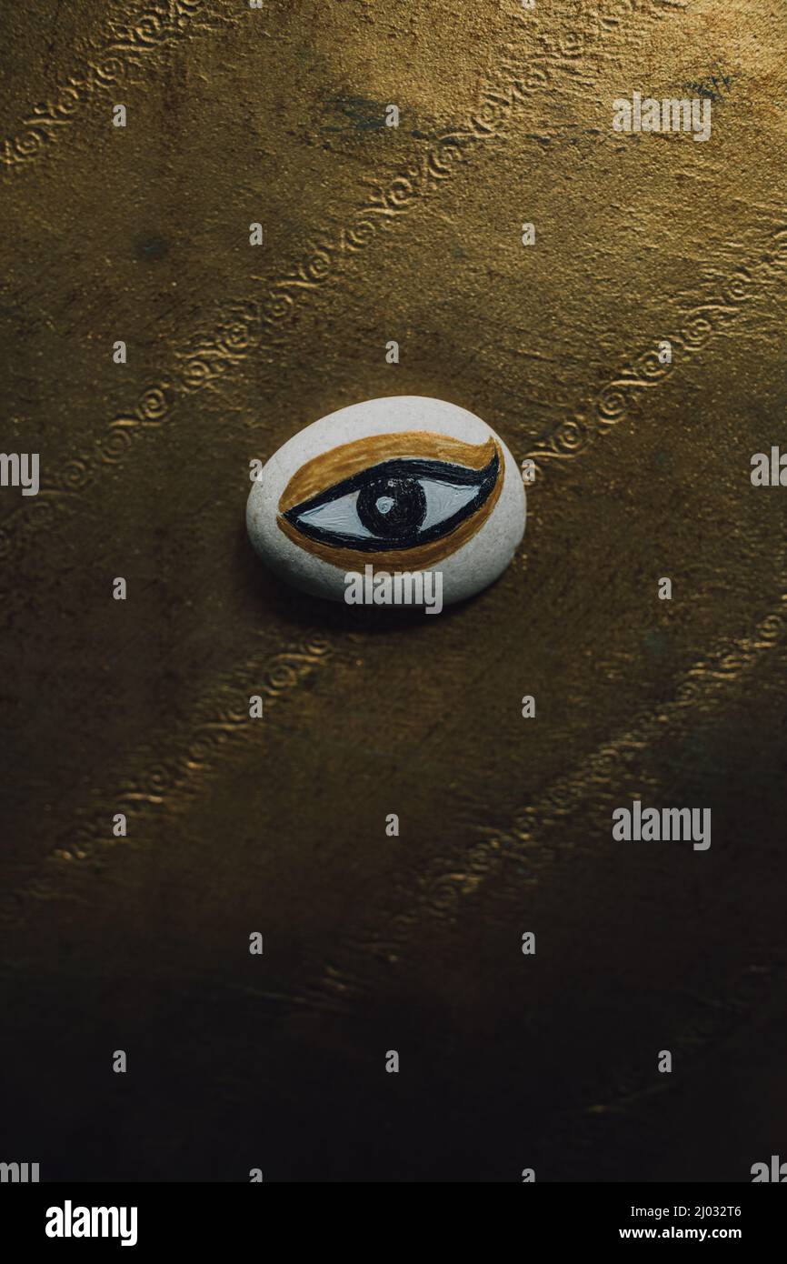 evil eye rock on gold tray Stock Photo - Alamy