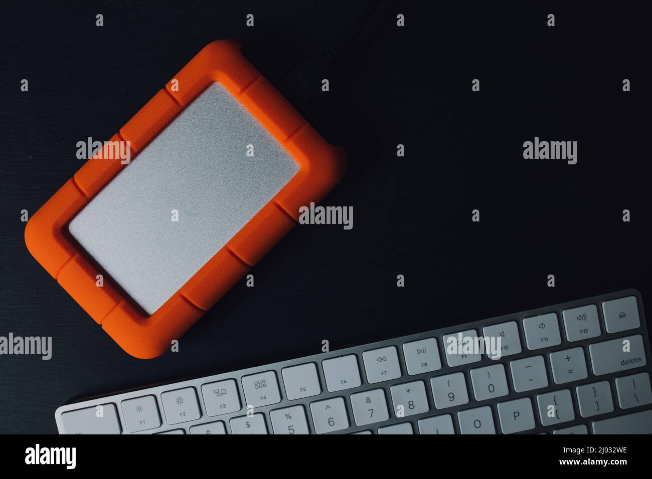 orange External hard drive on black desk Stock Photo - Alamy