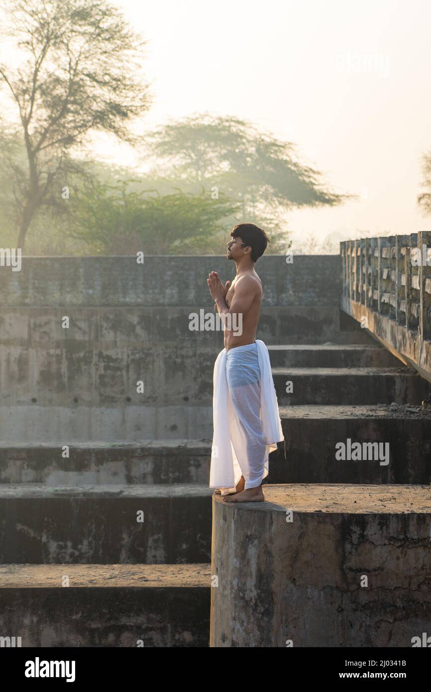 Vertical shot of a young Indian male praying to Hindu god - religion ...