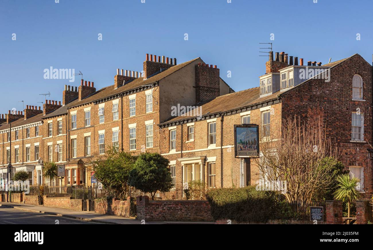 A street of terraced houses with a pub and a boarding house lit up by a ...