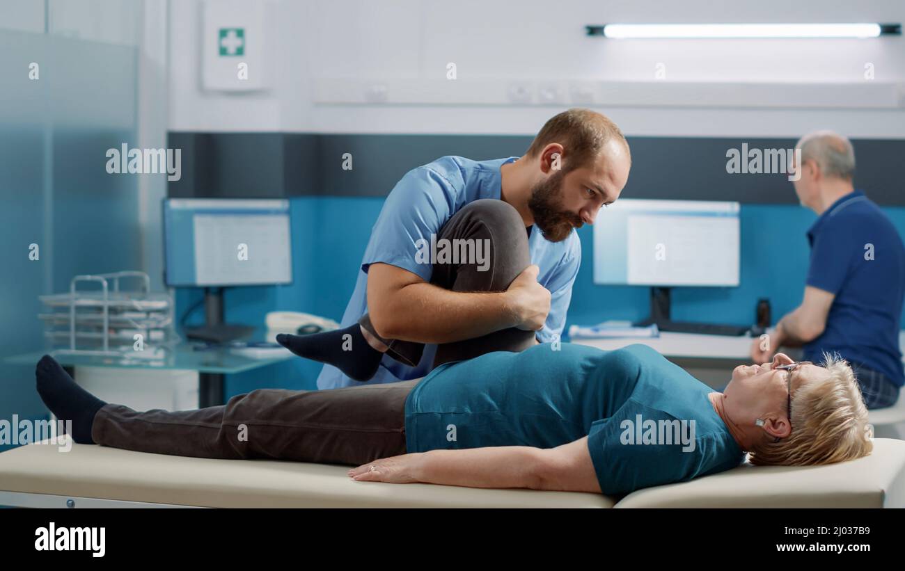 Therapist using leg raise exercise on elder person to crack bones and ...