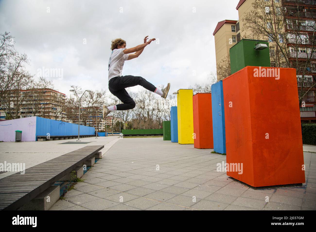 series of photos of young man jumping practicing parkour in the street ...