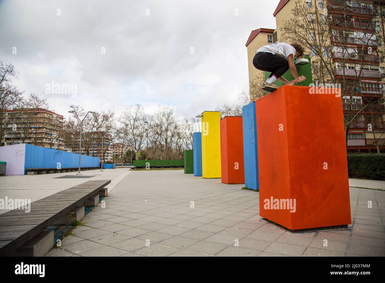 series of photos of young man jumping practicing parkour in the street ...