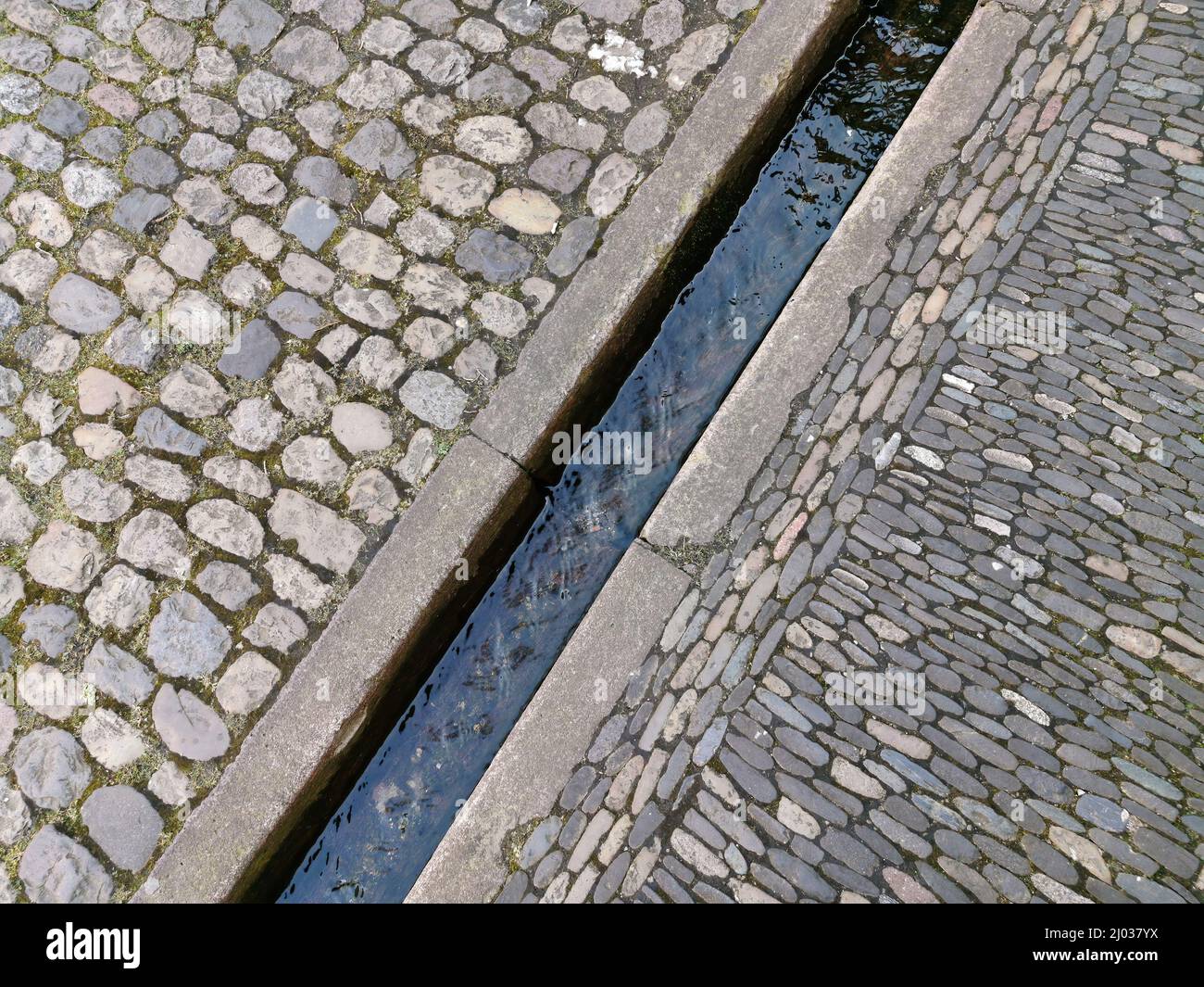 Wasserrinne im Kopfsteinpflaster in der Fußgängerzone einer Stadt ...