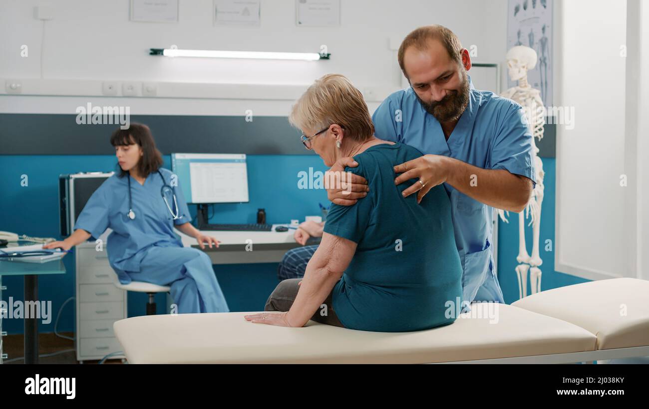 Therapist stretching back muscles and cracking spine bones at physical ...