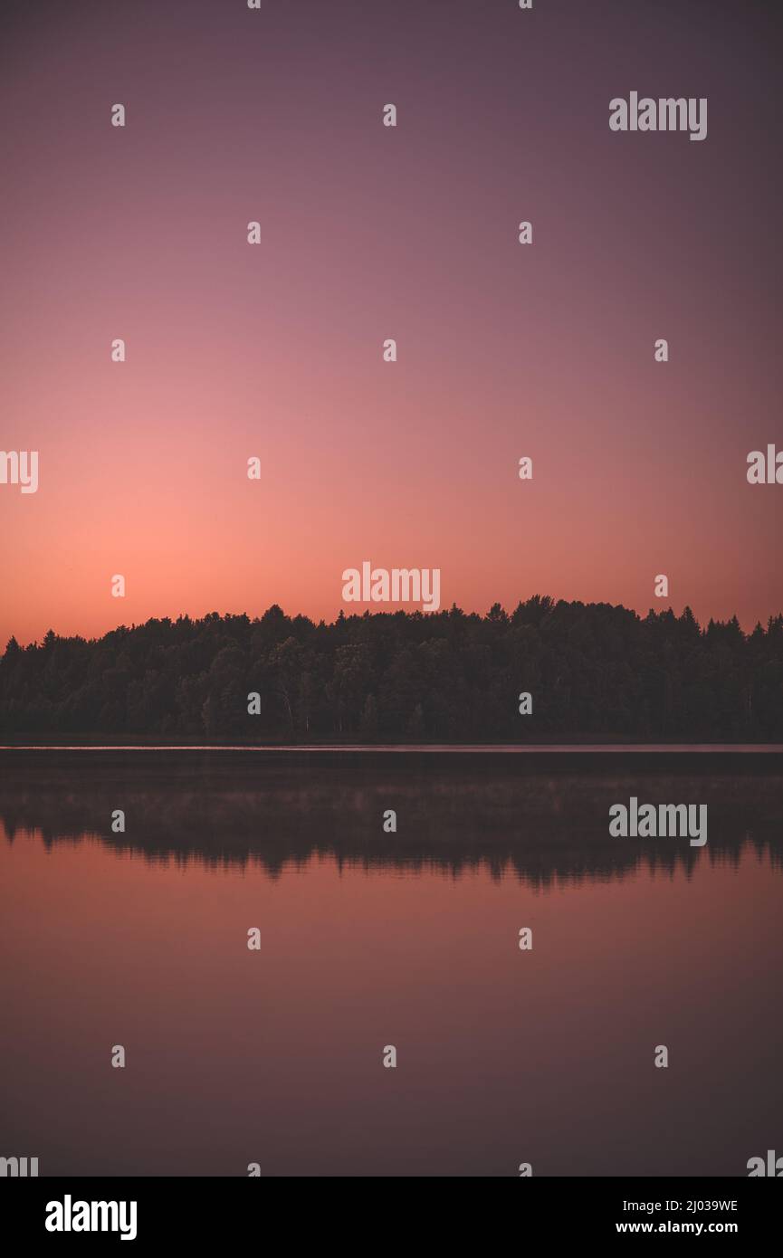 Calm lake with touch of red sunset Stock Photo - Alamy