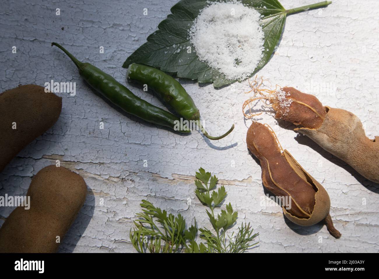Some raw tamarind with tamarind leaf Stock Photo - Alamy