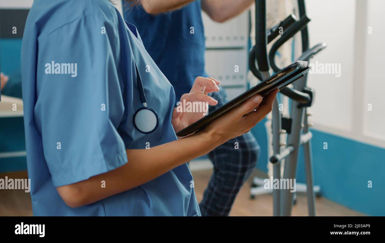 Health specialist in uniform using digital tablet to help senior ...