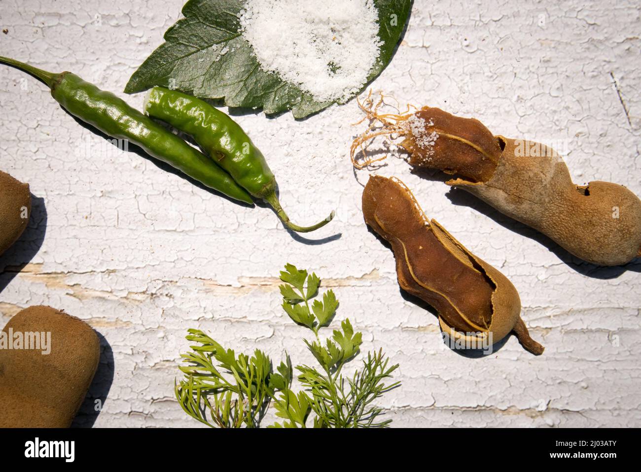 Some raw tamarind with tamarind leaf Stock Photo - Alamy