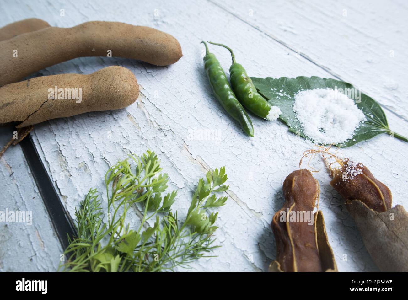 Some raw tamarind with tamarind leaf Stock Photo - Alamy