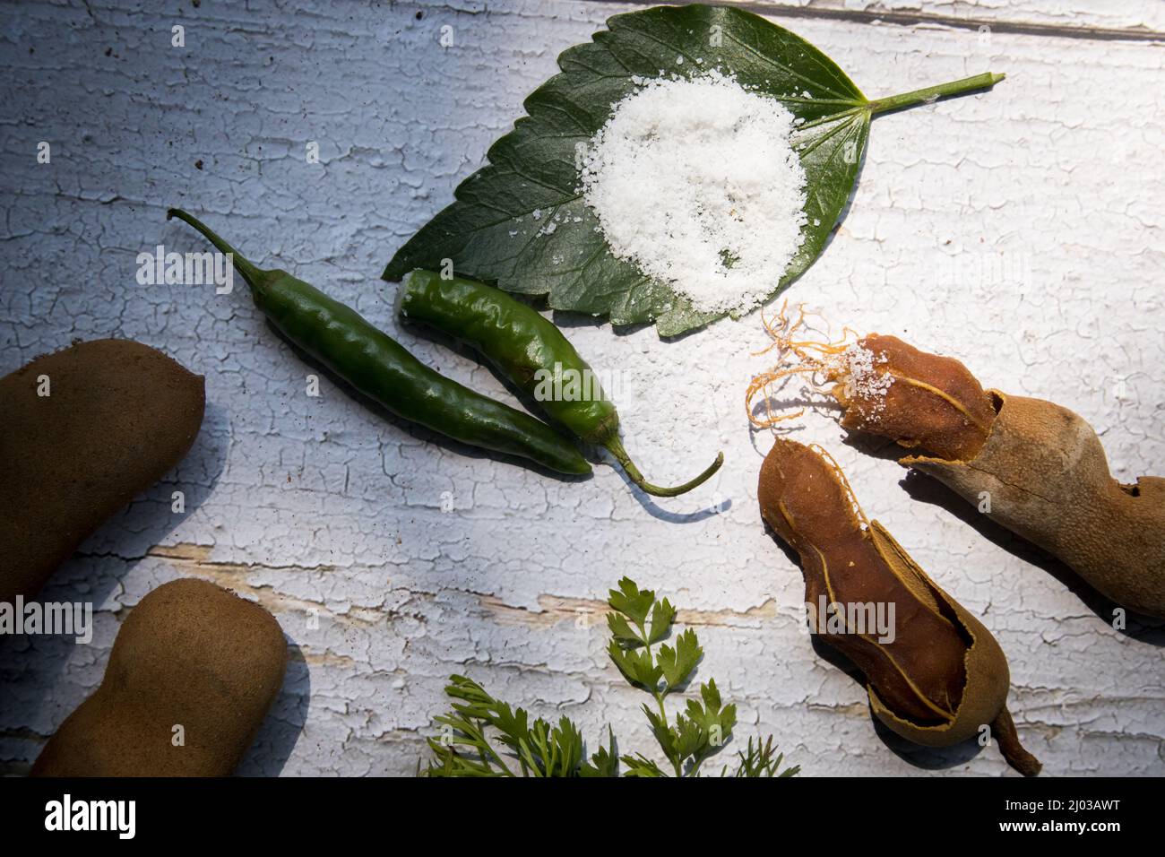 Some raw tamarind with tamarind leaf Stock Photo - Alamy