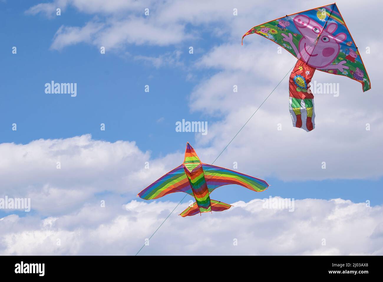 colorful kites in blue sky with small white clouds Stock Photo - Alamy