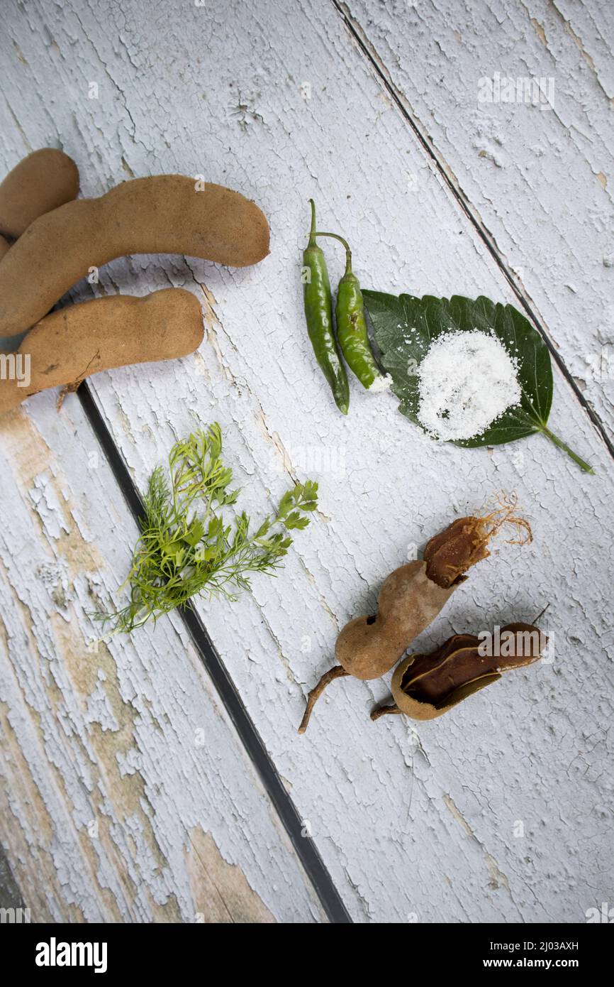 Some raw tamarind with tamarind leaf Stock Photo - Alamy