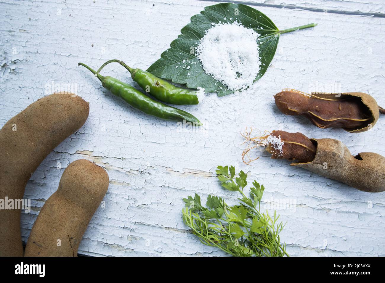 Some raw tamarind with tamarind leaf Stock Photo - Alamy