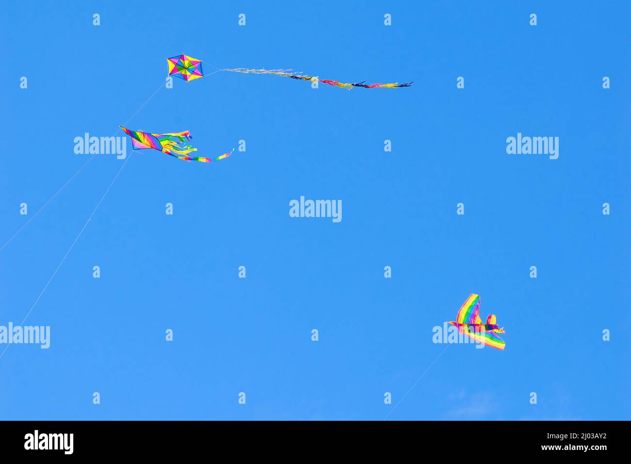 colorful kites in blue sky with small white clouds Stock Photo - Alamy