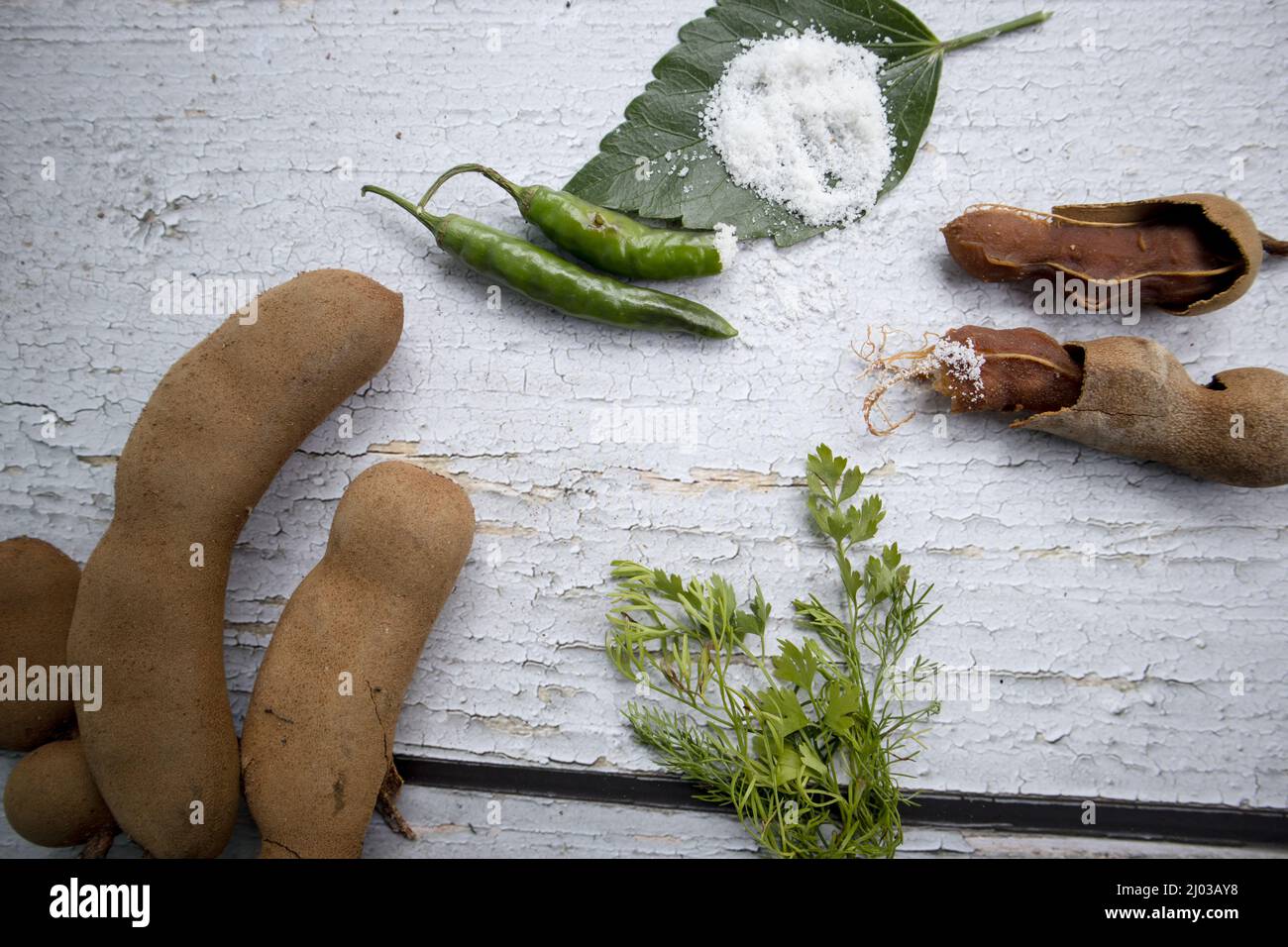 Some raw tamarind with tamarind leaf Stock Photo - Alamy