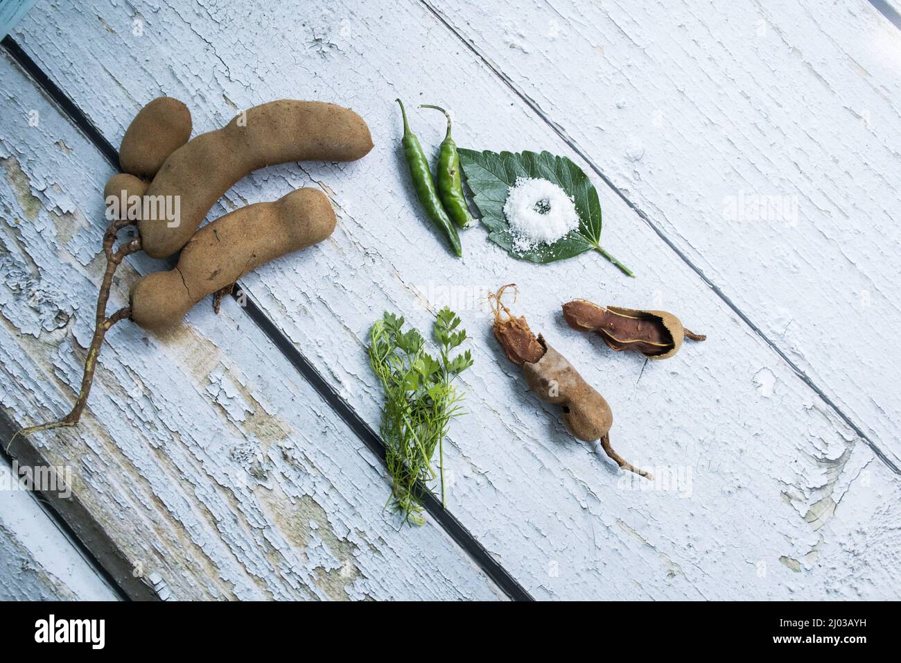 Some raw tamarind with tamarind leaf Stock Photo - Alamy