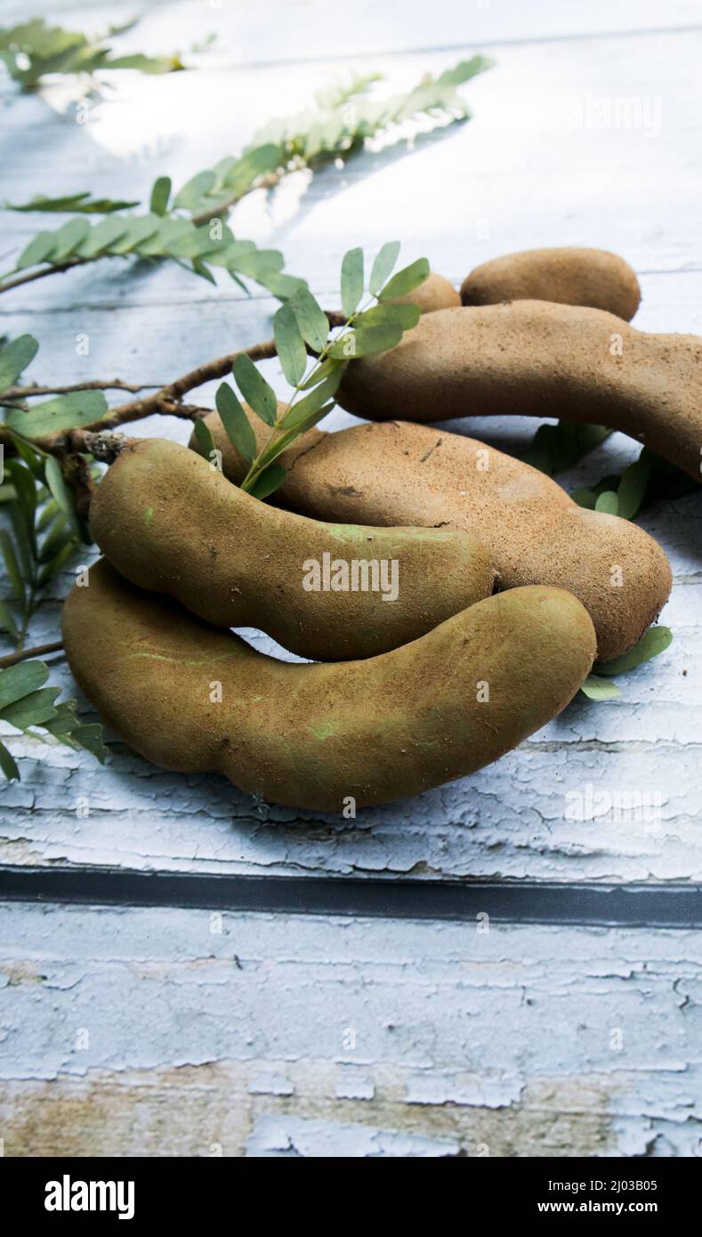 Some raw tamarind with tamarind leaf Stock Photo - Alamy