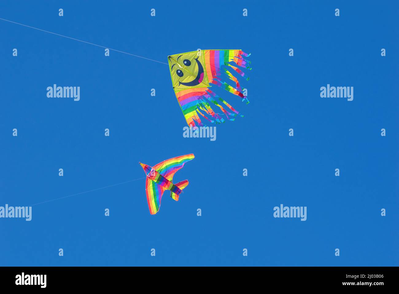 colorful kites in blue sky with small white clouds Stock Photo - Alamy