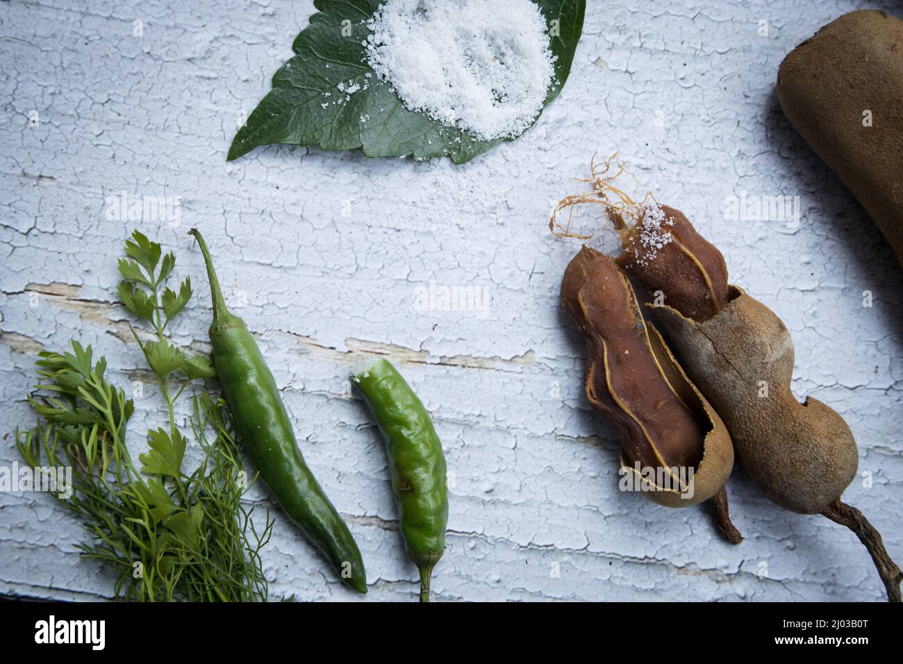 Some raw tamarind with tamarind leaf Stock Photo - Alamy