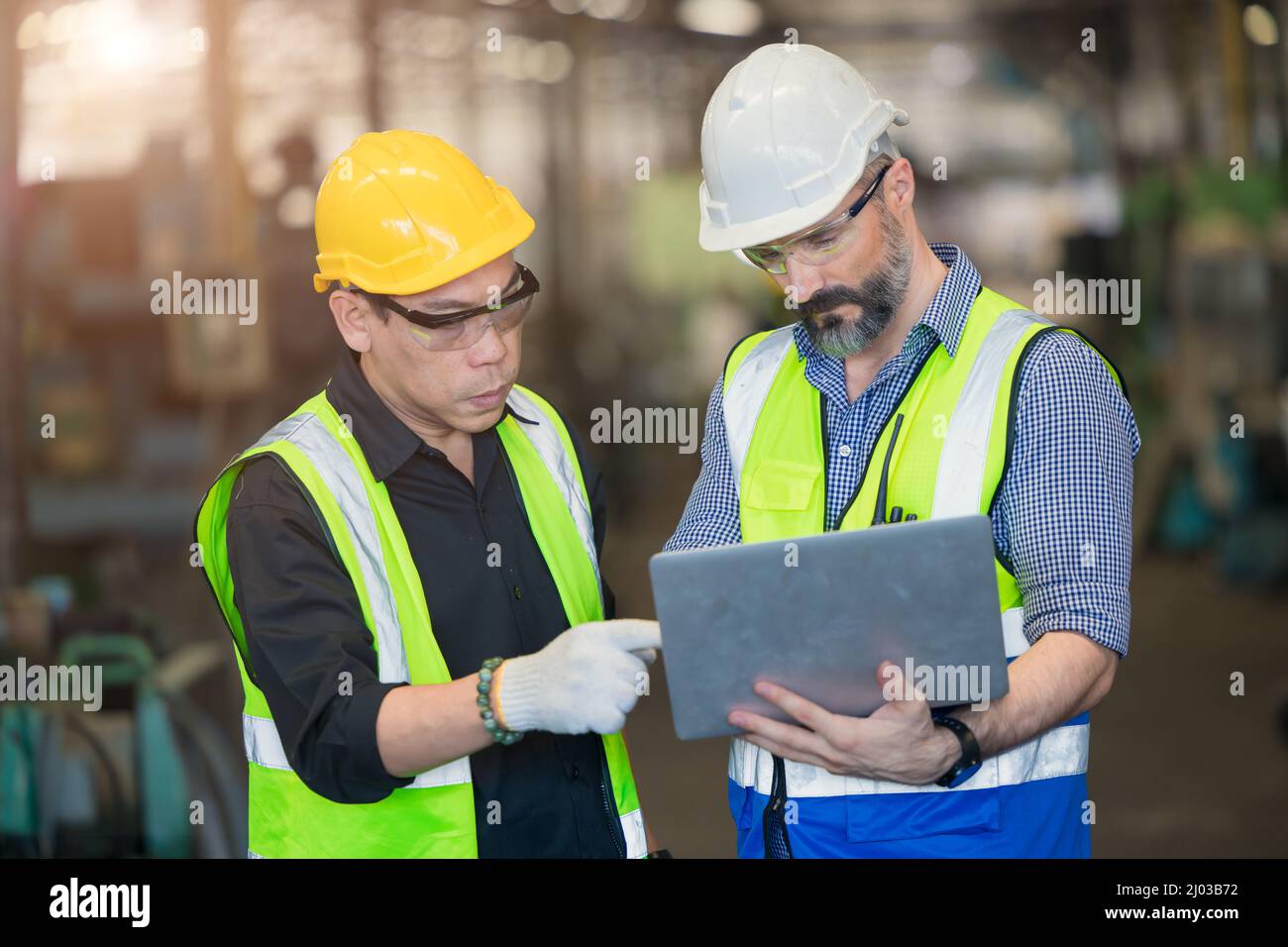 chief engineer talking with staff worker looking detail in laptop ...