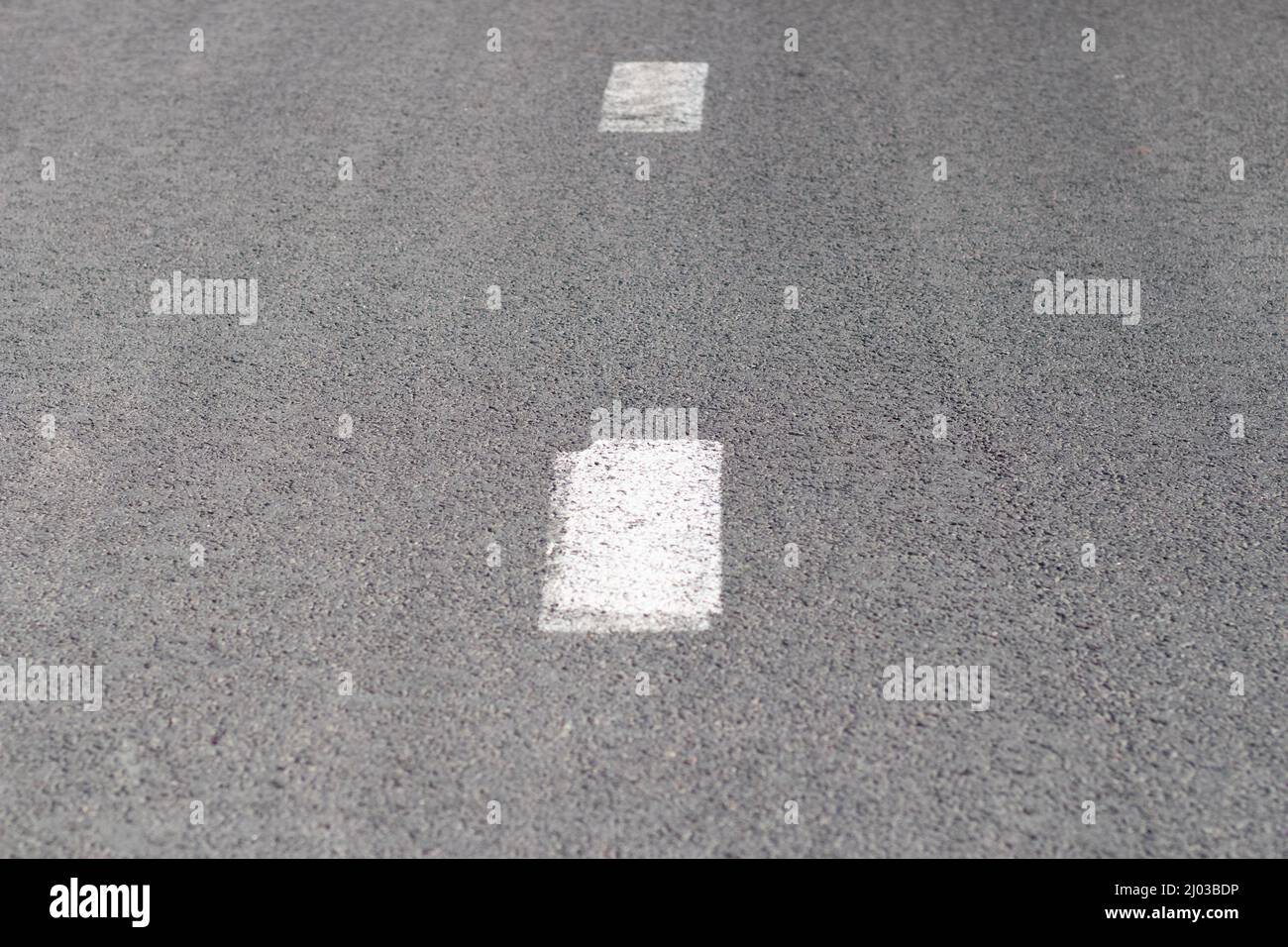 Road markings. An intermittent white stripe on an asphalt road. Urban ...