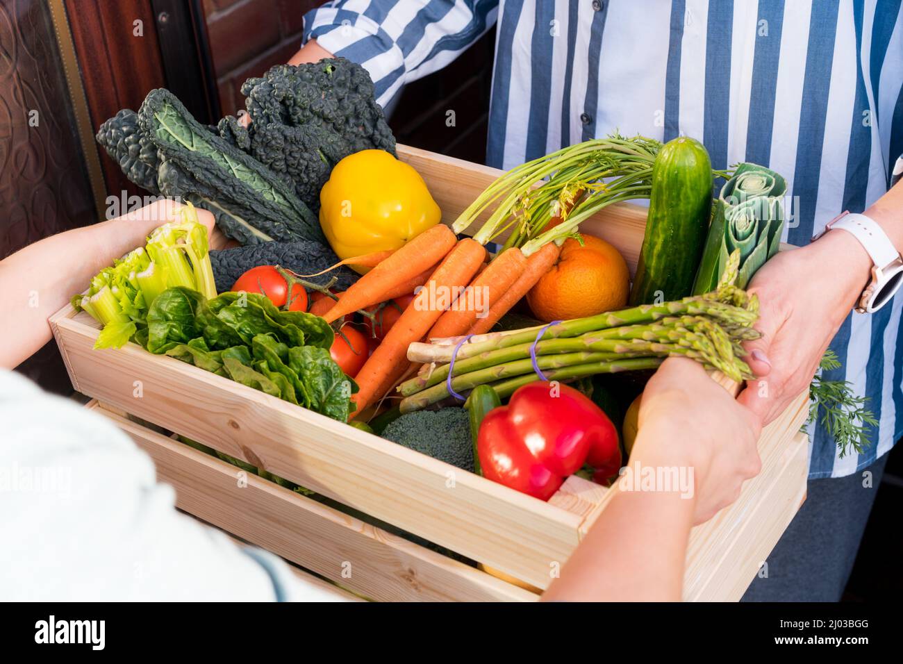 Home food delivery. Close up woman taking wooden box with fresh ...
