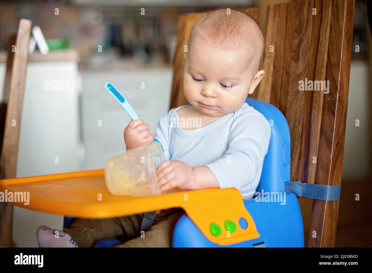 Little baby boy, eating mashed food for the first time in his life ...