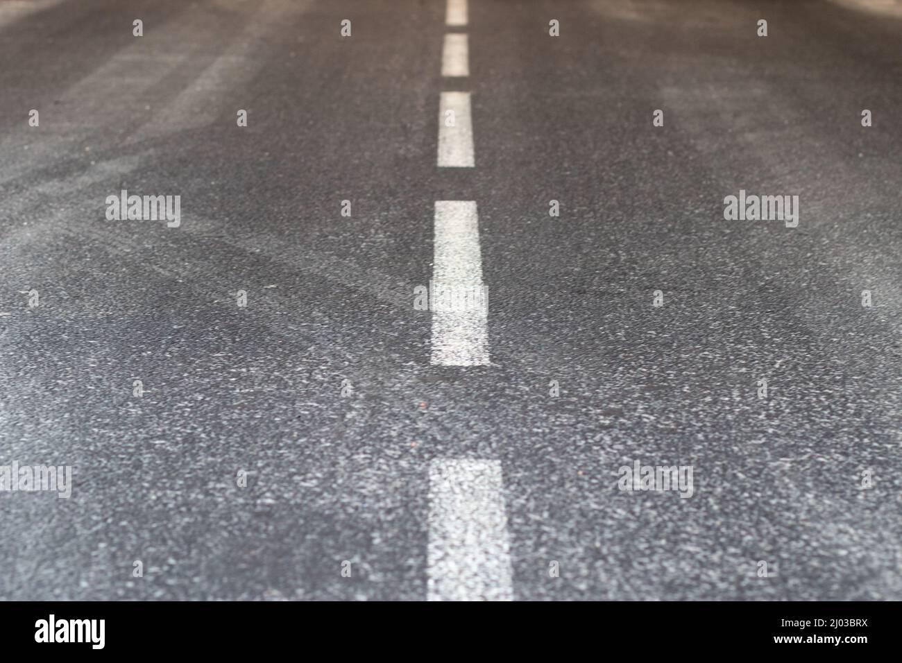 Road markings. An intermittent white stripe on an asphalt road. Urban ...