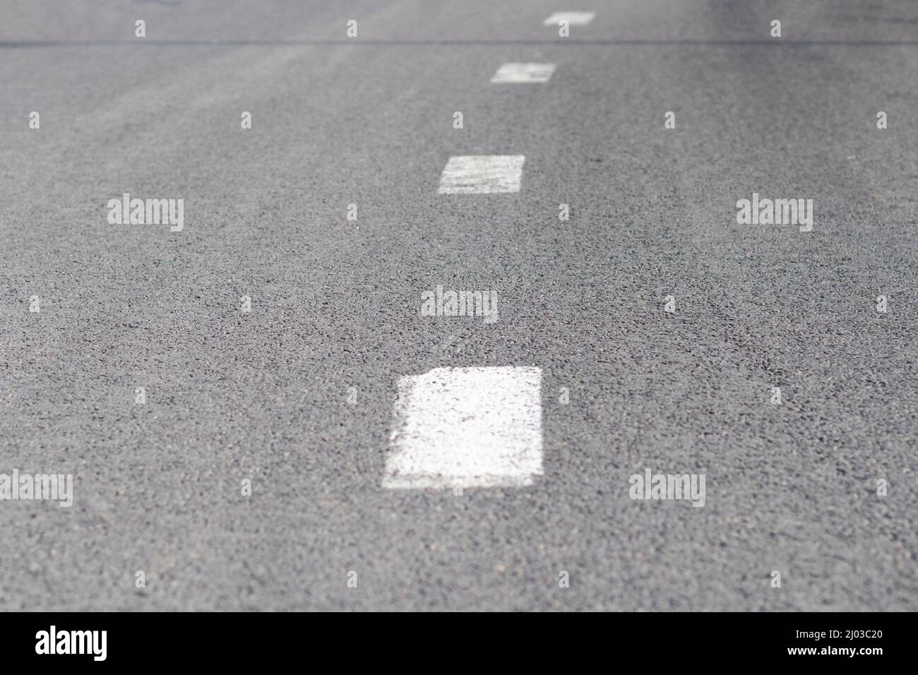 Road markings. An intermittent white stripe on an asphalt road. Urban ...