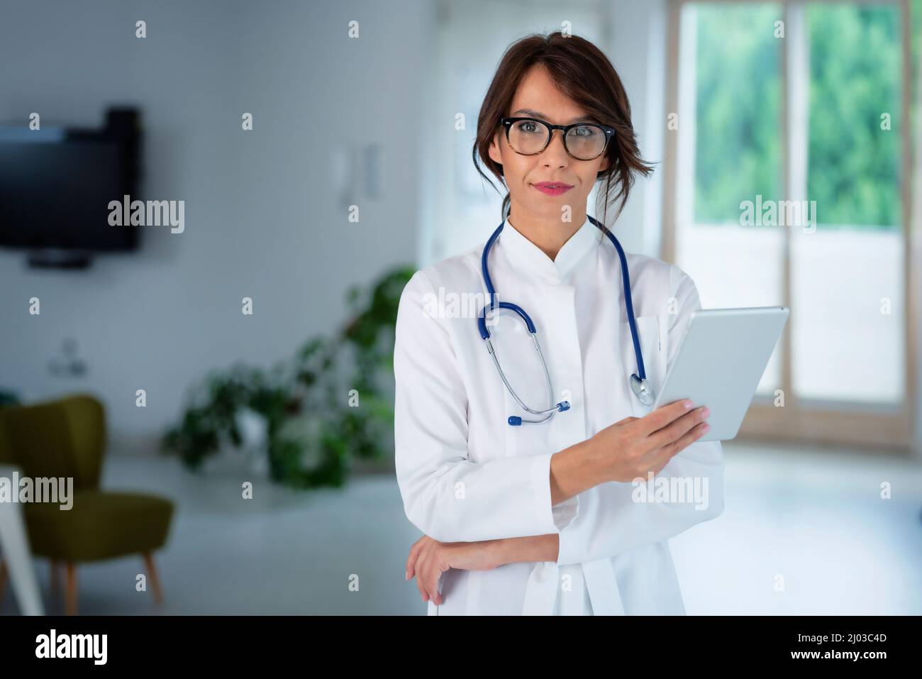 Portrait of a female doctor holding her patient chart on digital tablet ...