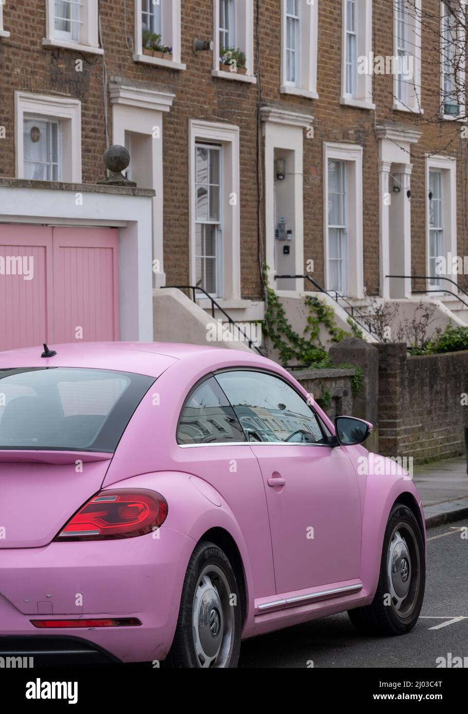 Cute pink Volkwagen Beetle retro style car, parked in front of a pink ...