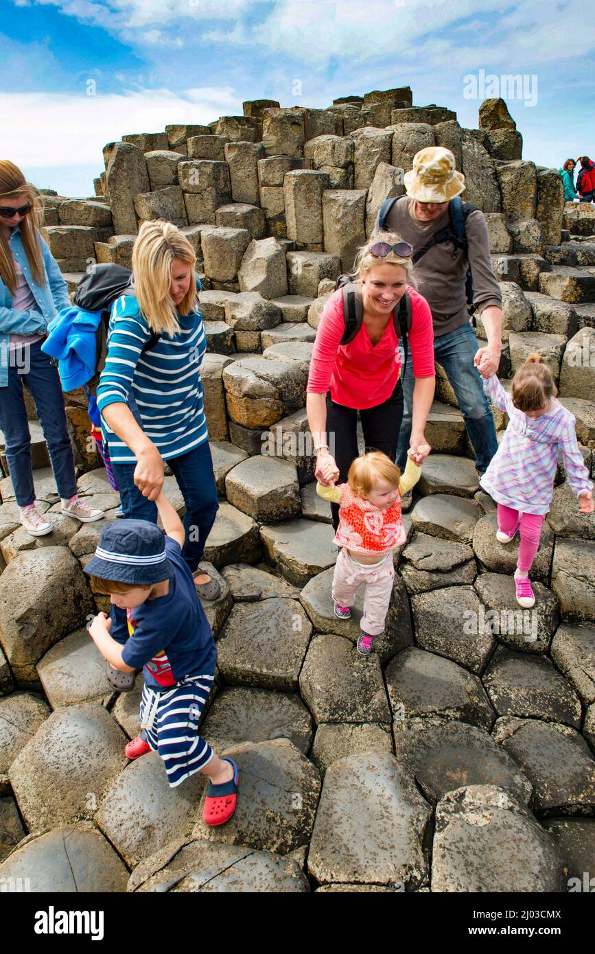 Family climbing on the UNESCO World Heritage Site the Giant's Causeway ...