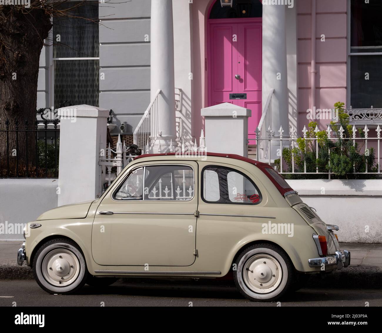Beige coloured vintage Fiat 500 classic car parked in front of a house ...