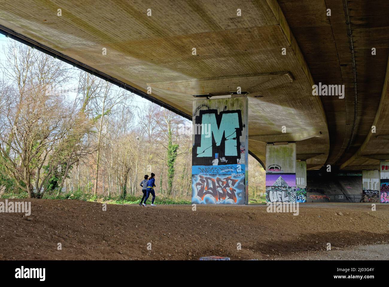 Two young female runners passing under the large dominating elevated ...