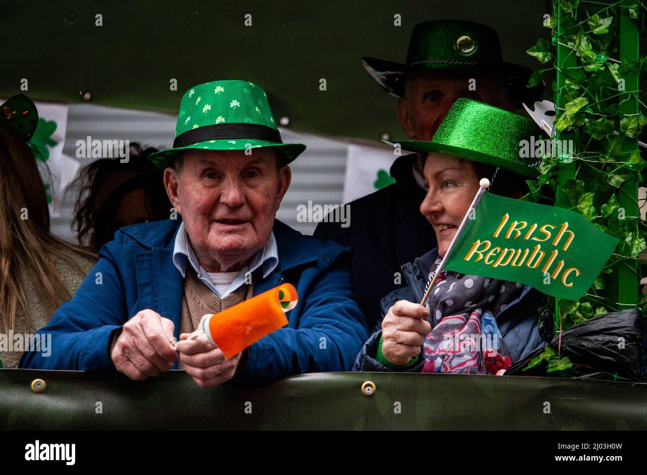 An older couple on a carnival float with Irish flags at St Patrick's ...