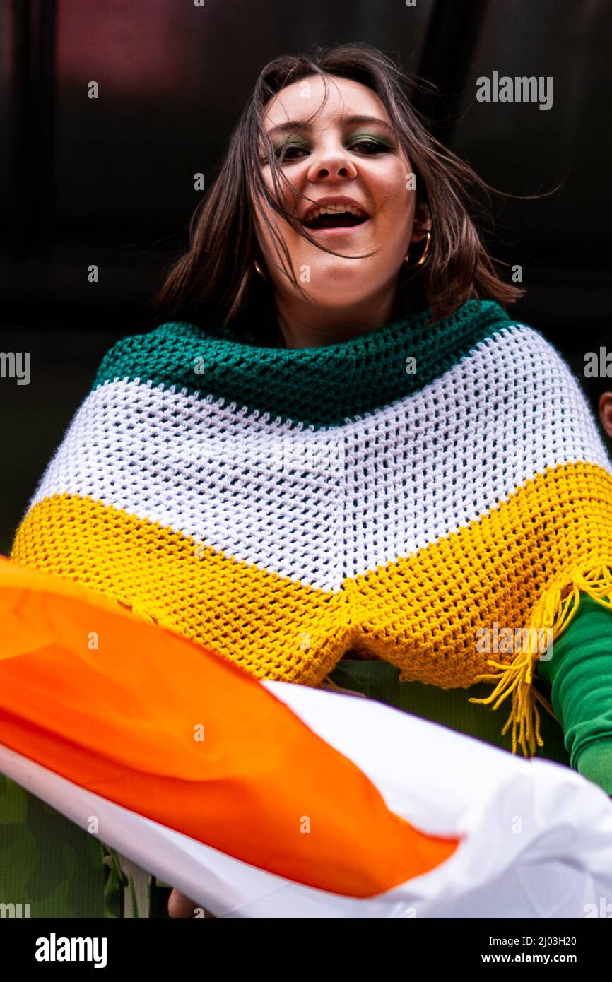 A young woman on a float waving the Irish flag at St Patrick's Parade ...