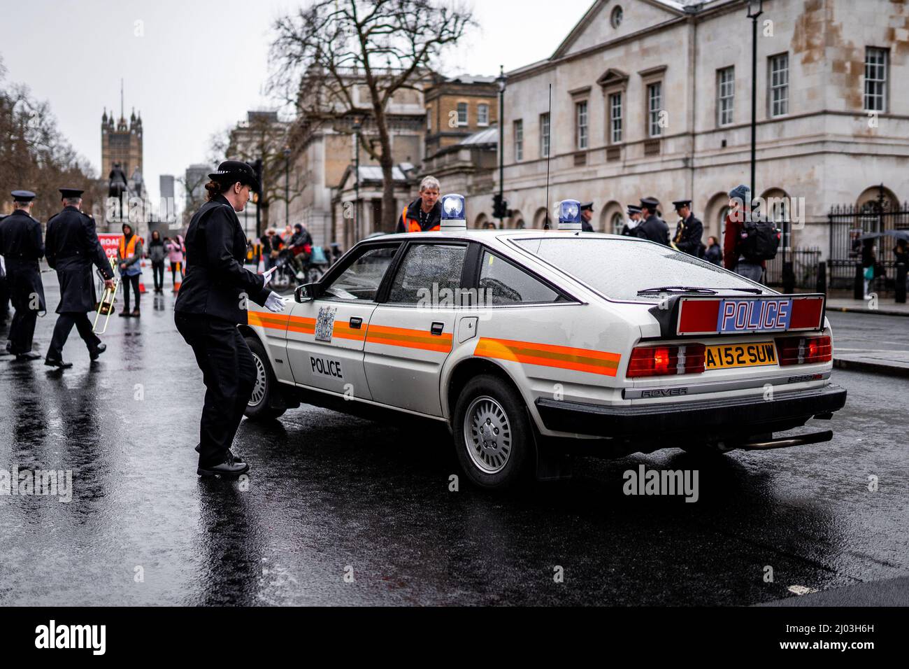 A police officer getting into an old police car at St Patrick's Parade ...
