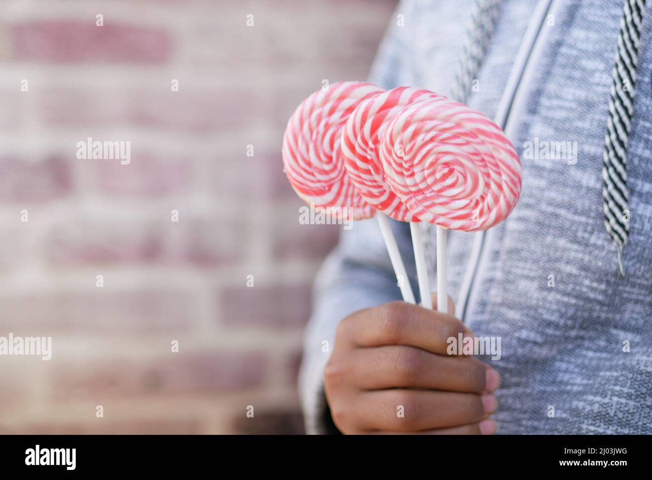 Hand holding lollipop hi-res stock photography and images - Alamy