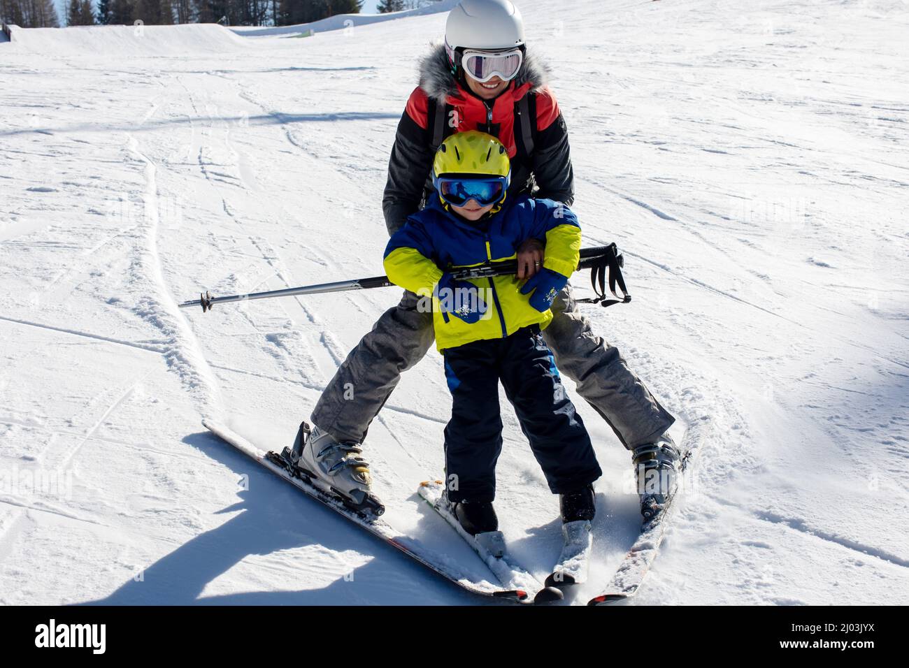 Happy family, skiing in Italy on a sunny day, kids and adults skiing ...