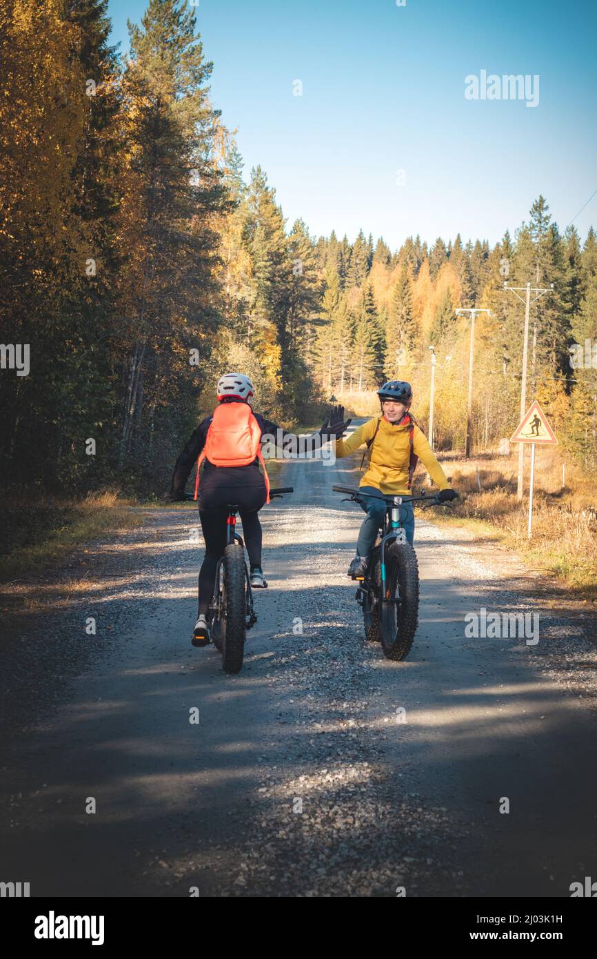 Cycling friends greet each other as they meet on a dirt road in ...