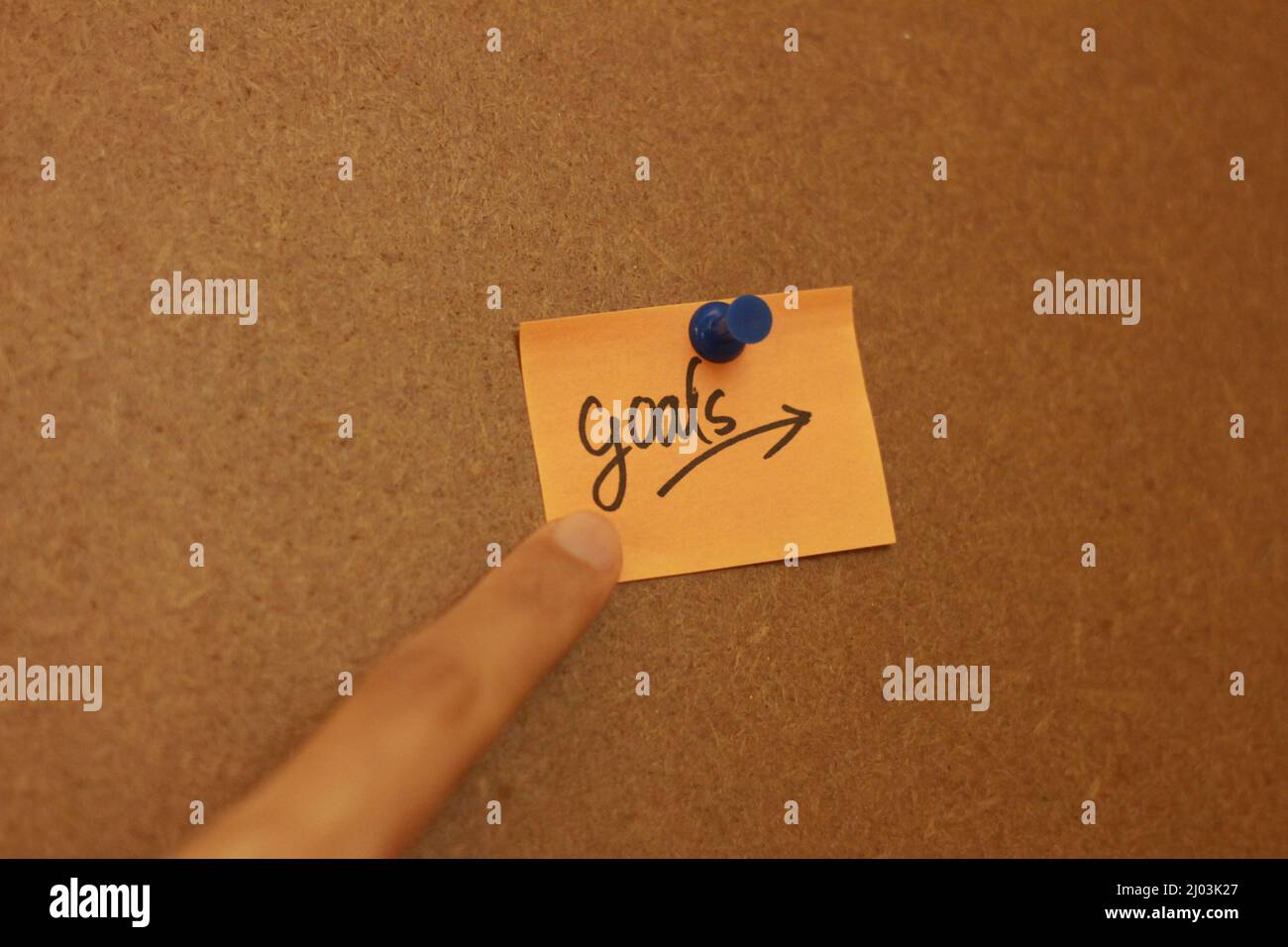 Goals text written on sticky note concept designed with woman hand ...