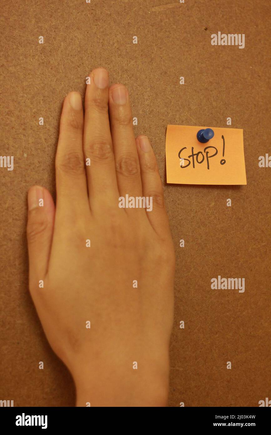 Stop text written on sticky note designed with woman hand Stock Photo ...