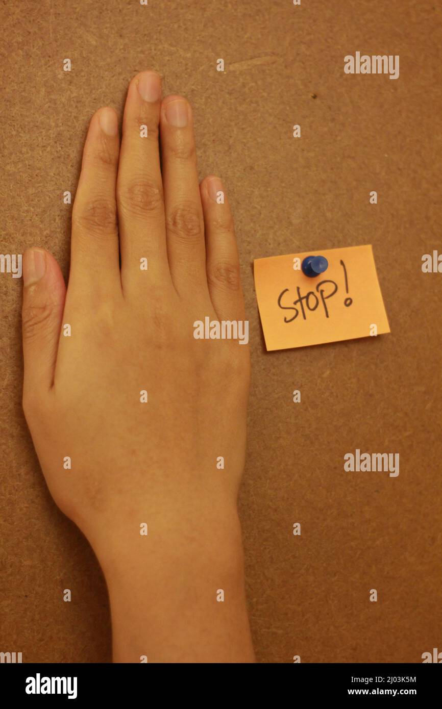 Stop text written on sticky note designed with woman hand Stock Photo ...