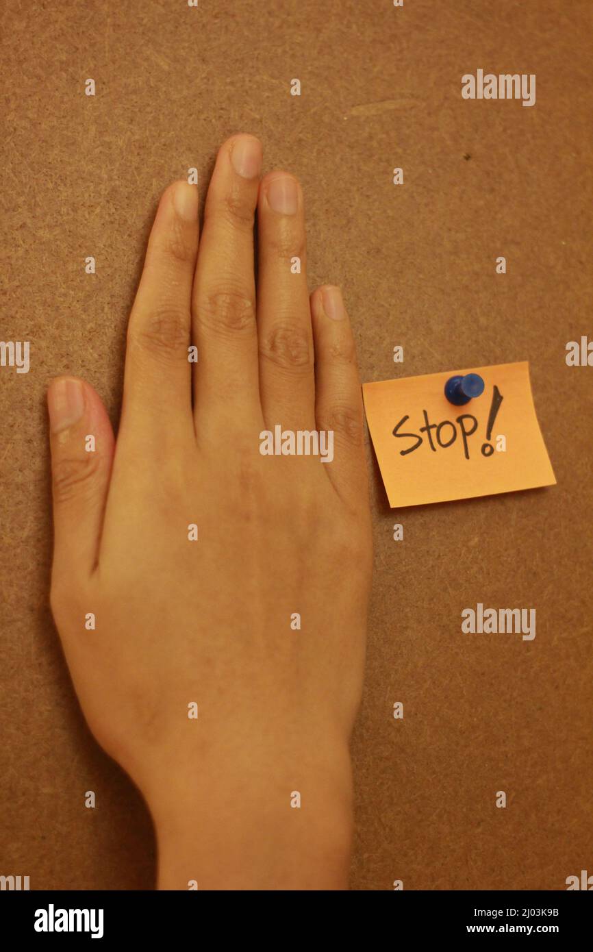Stop text written on sticky note designed with woman hand Stock Photo ...