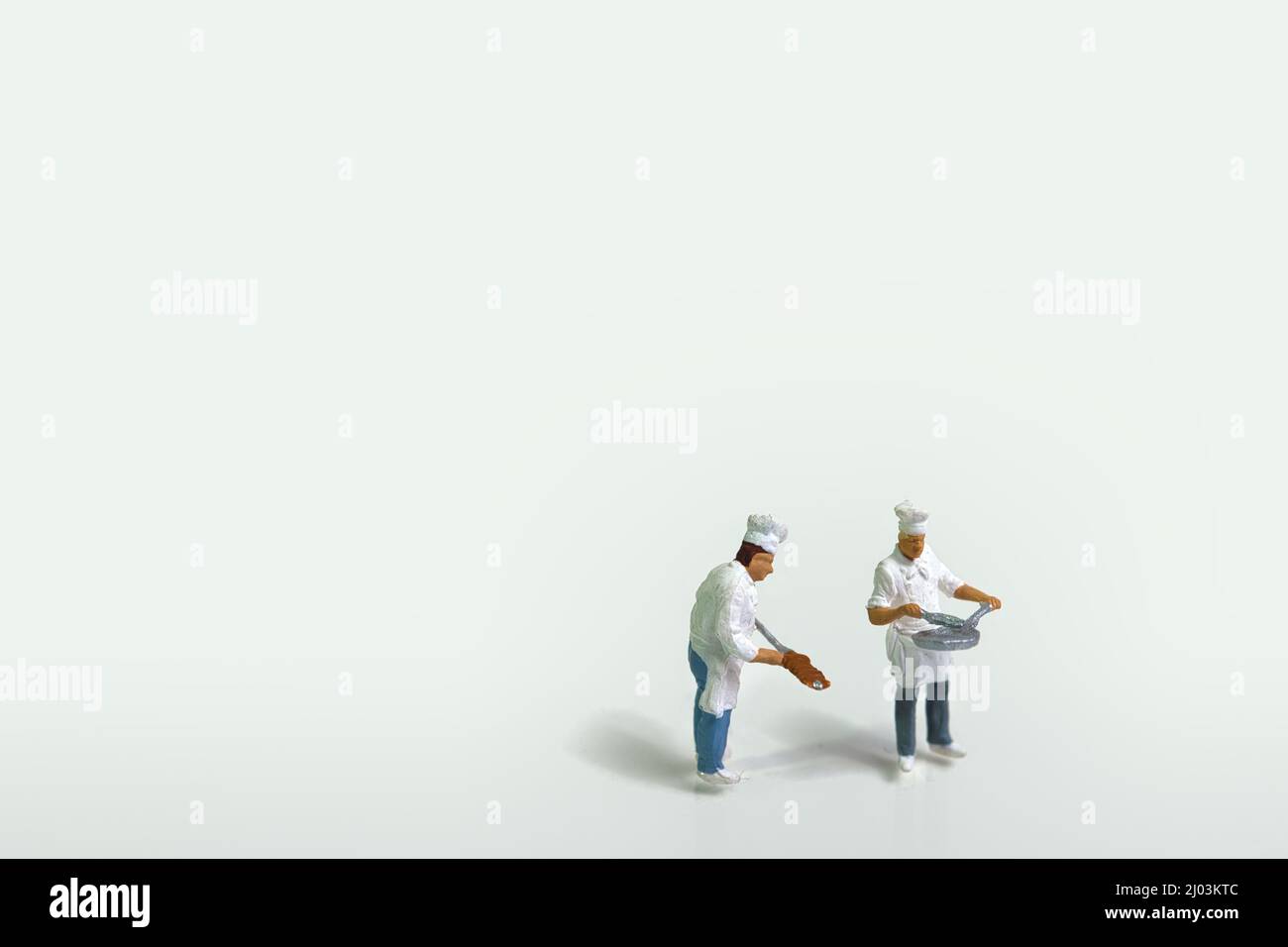 two cooks in work clothes and cookware Stock Photo - Alamy