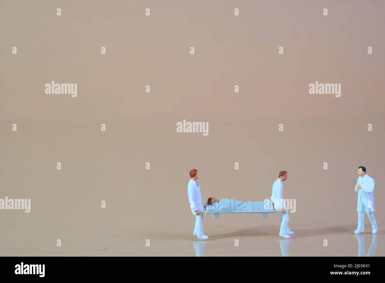 two male nurses in white coats carry a patient with a stretcher to a ...