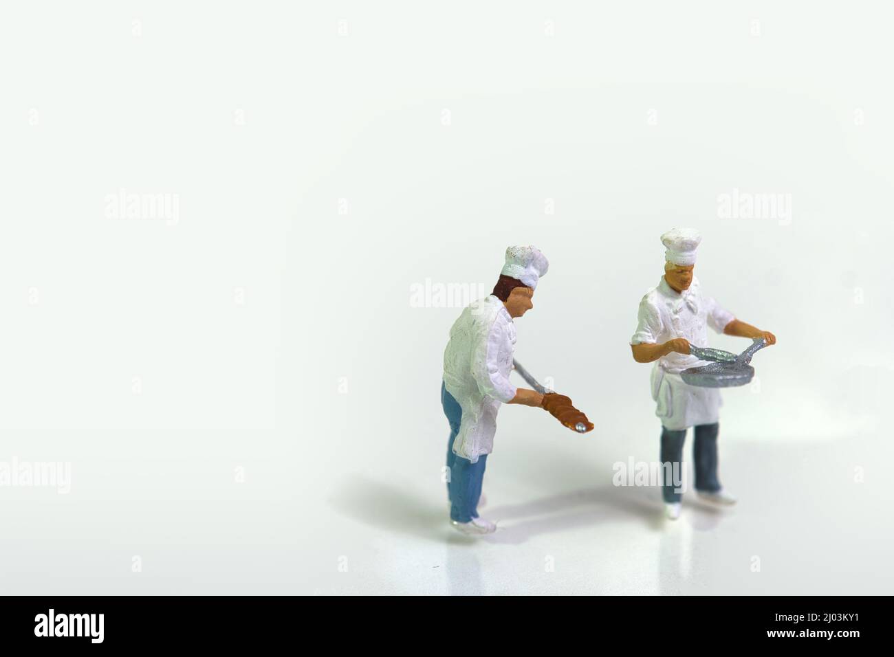 two cooks in work clothes and cookware Stock Photo - Alamy